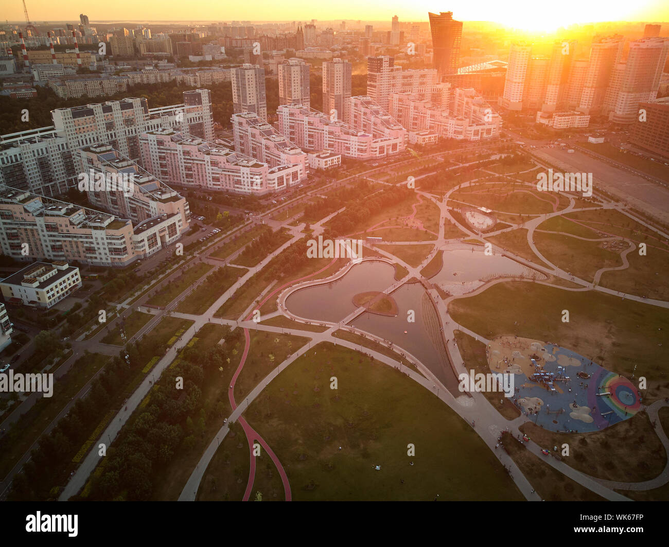Newly built city park with playgrounds and ponds in the evening sun ...