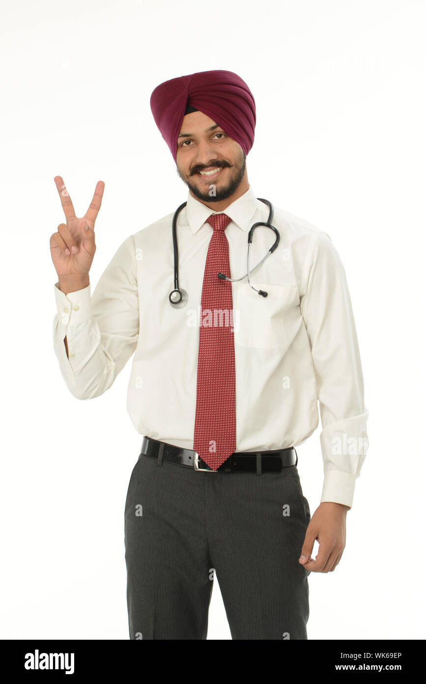 Male doctor standing and showing V sign Stock Photo - Alamy