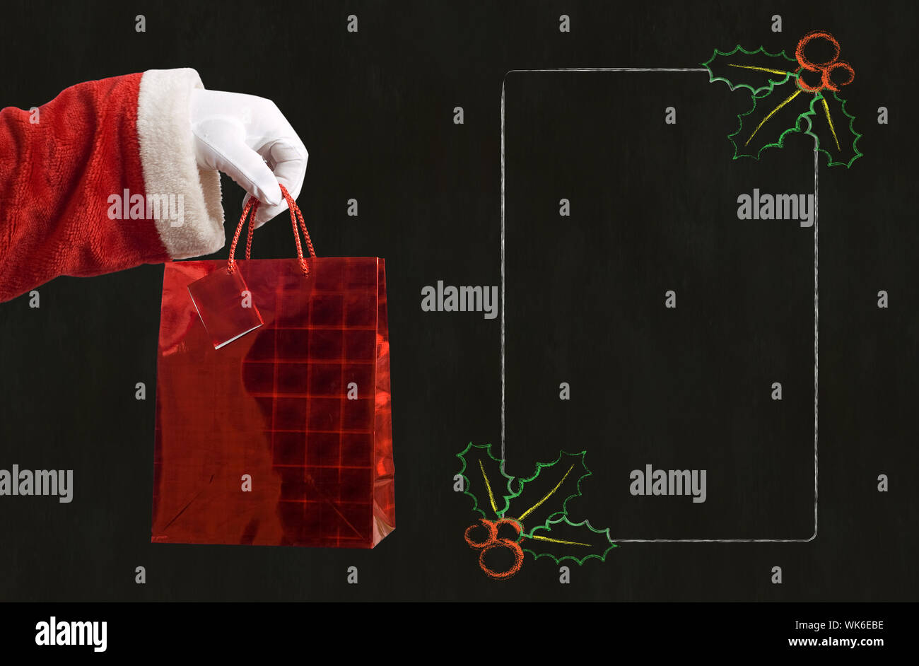 Father Christmas hand holding a red present with notes Stock Photo - Alamy