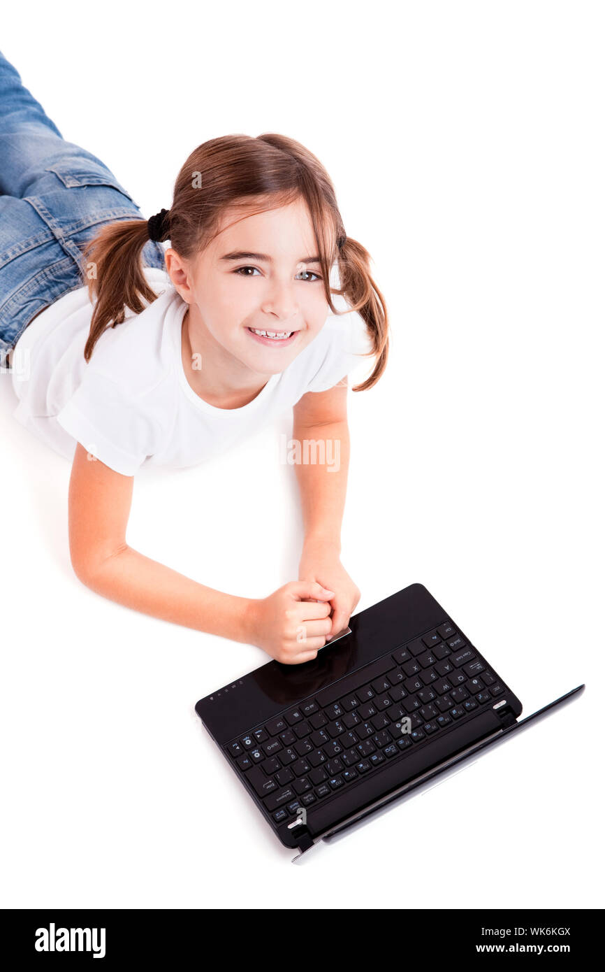Little girl lying on floor working with a laptop Stock Photo - Alamy