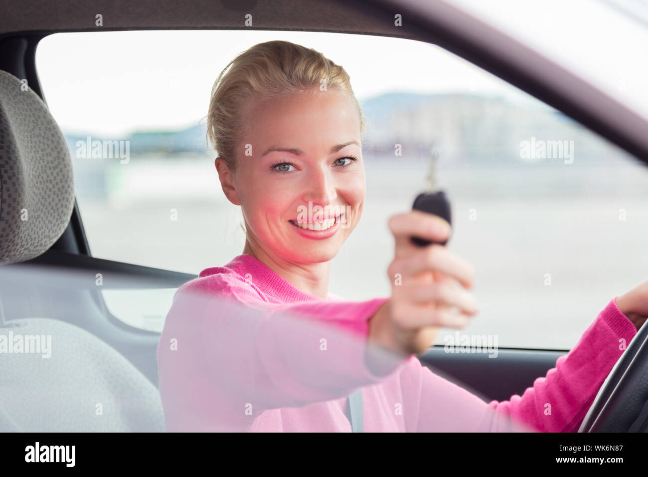 Woman driver showing car keys. Young female driving happy about her new ...