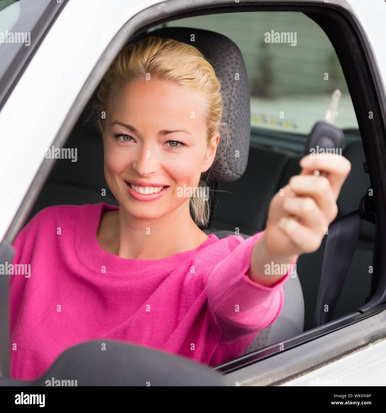 Woman driver showing car keys. Young female driving happy about her new ...