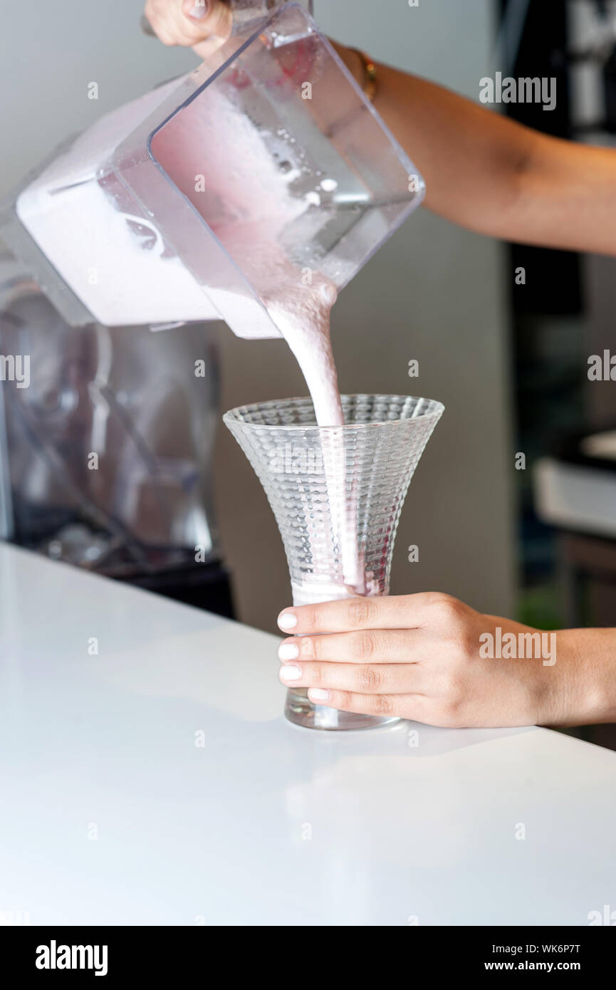 Close-up of woman pouring milkshake into glass Stock Photo - Alamy