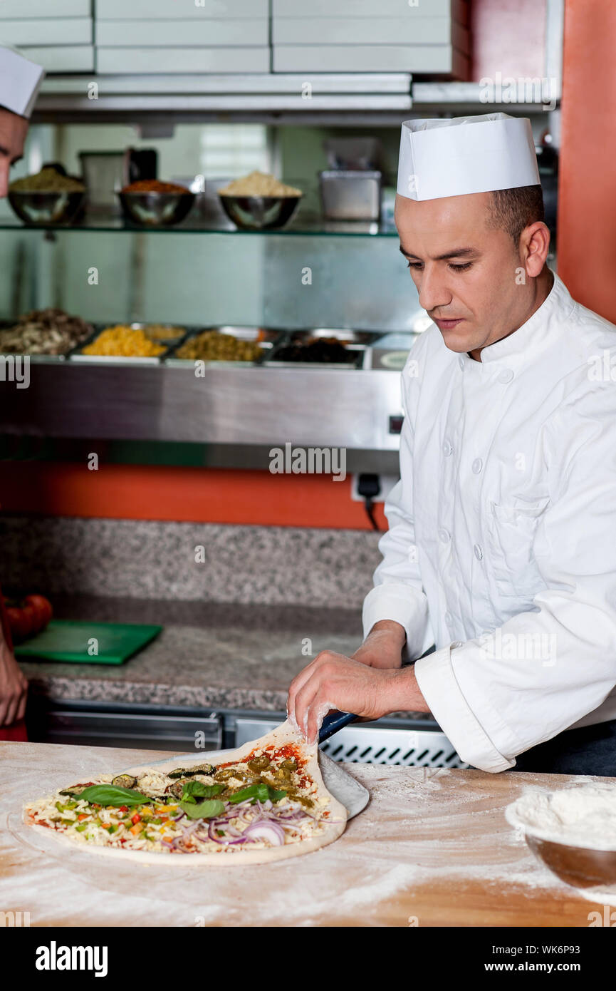 Chef trying to take out the pizza dough Stock Photo - Alamy
