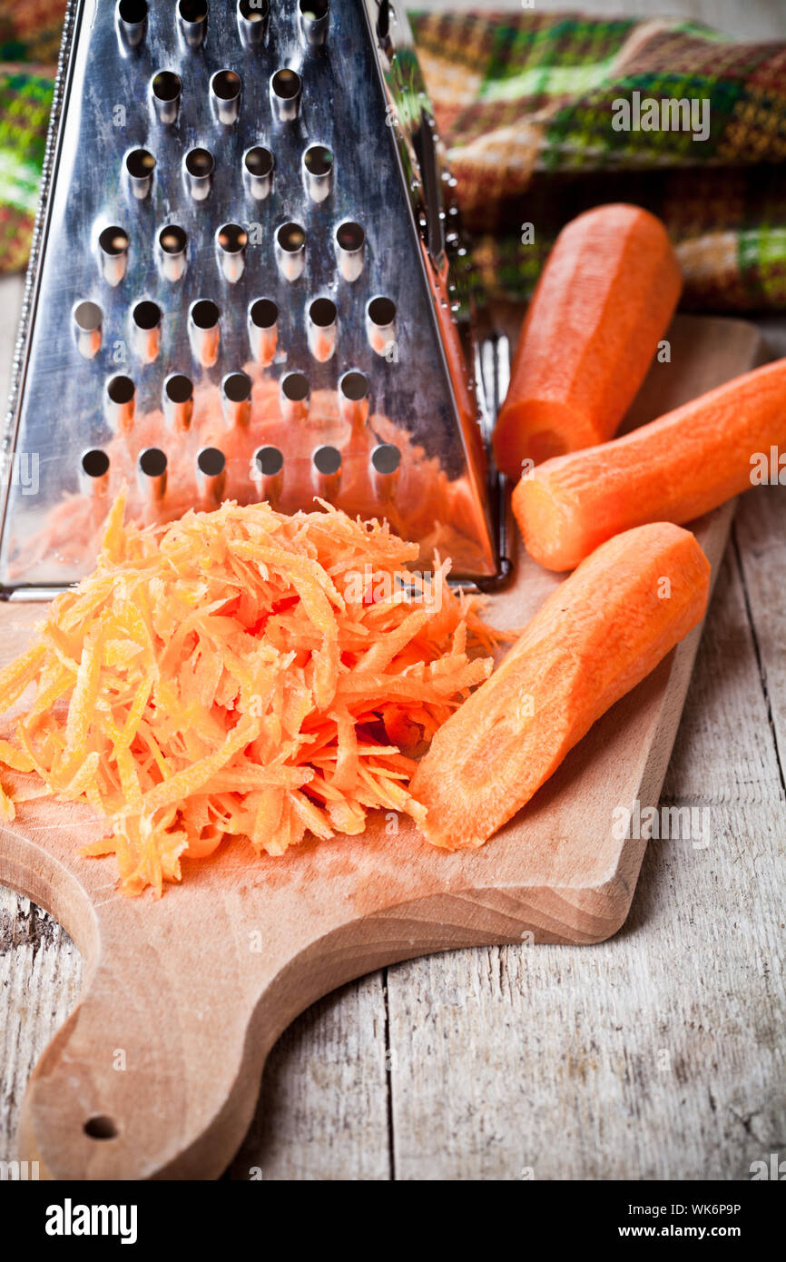 metal grater and fresh carrots closeup on cutting board Stock Photo - Alamy