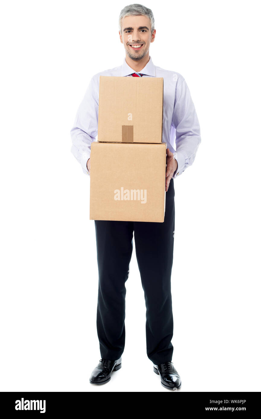Smiling corporate man holding stack of boxes Stock Photo - Alamy