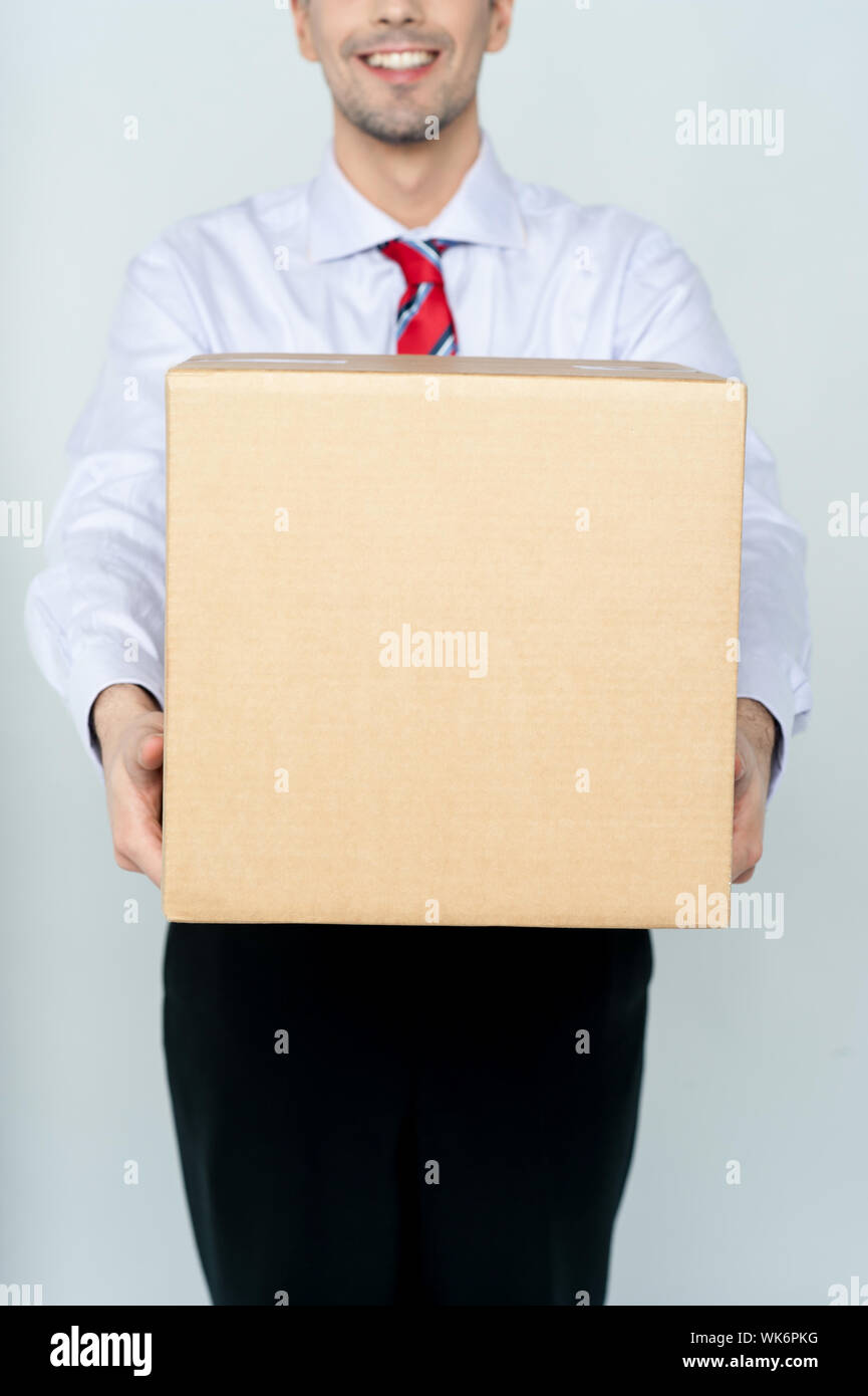 Delivery man holding a big parcel Stock Photo - Alamy