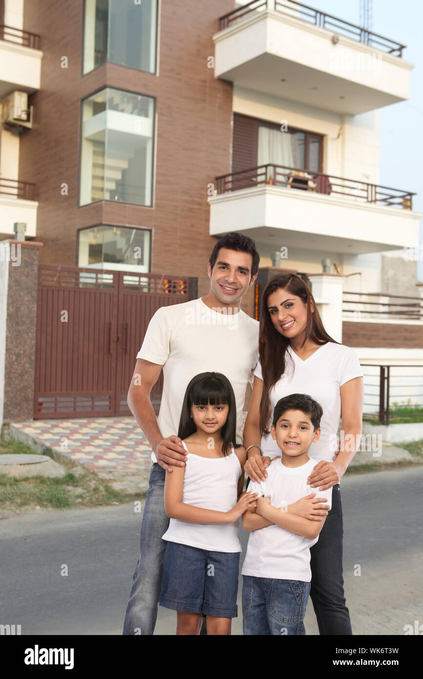 Family standing together in front of house Stock Photo - Alamy