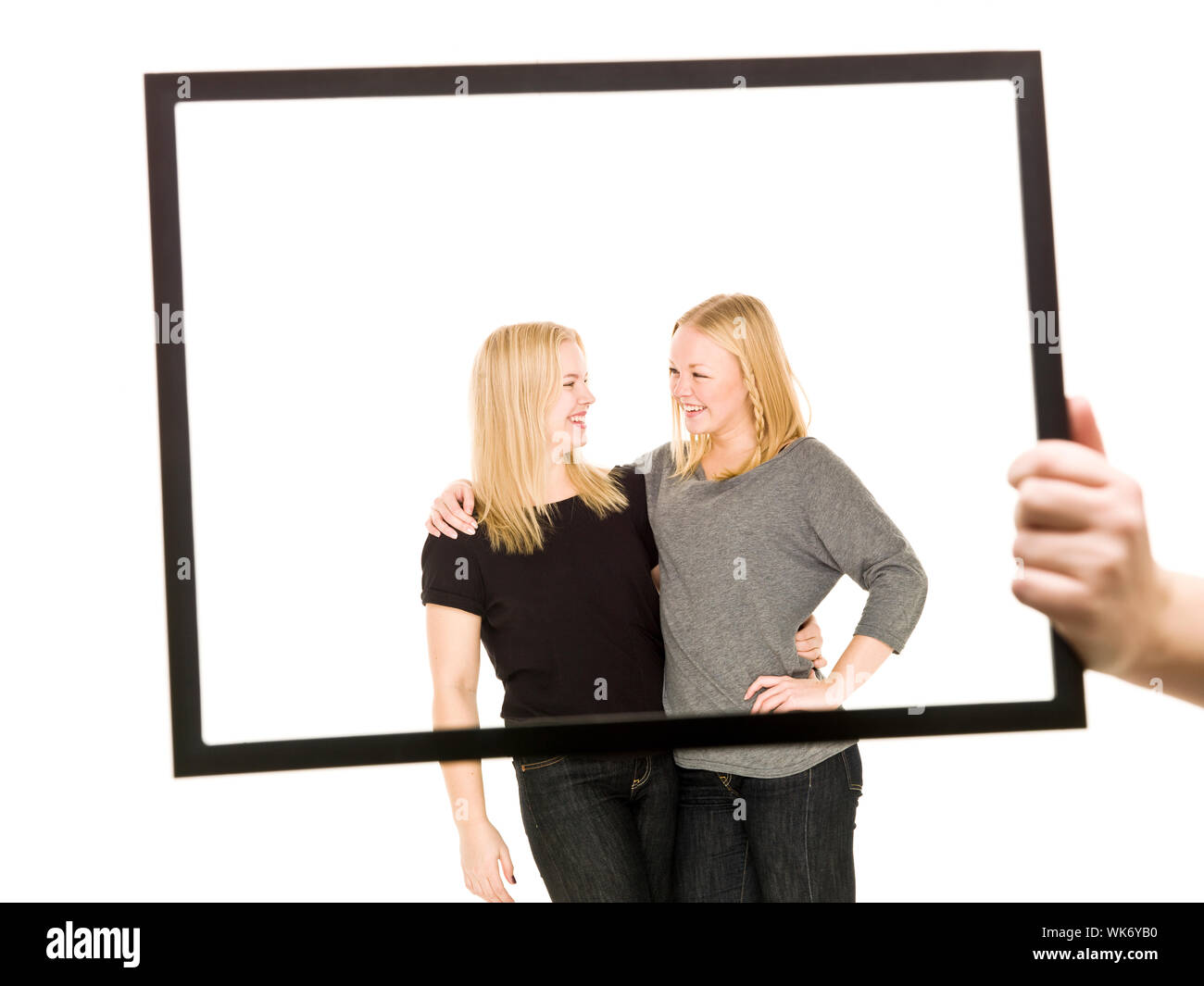 Two blond girls in a frame isolated on white background Stock Photo - Alamy