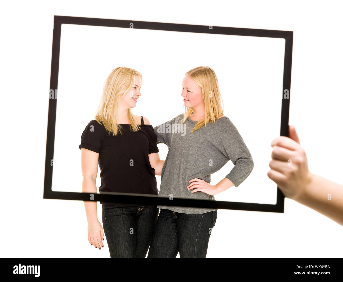 Two blond girls in a frame isolated on white background Stock Photo - Alamy