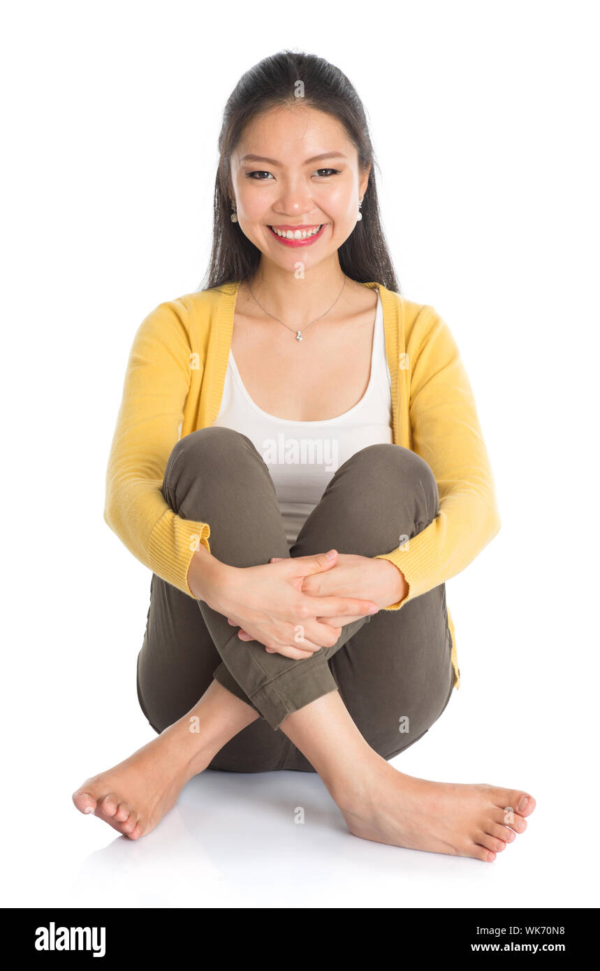 Full body Asian woman in yellow blouse seated on floor, isolated on ...
