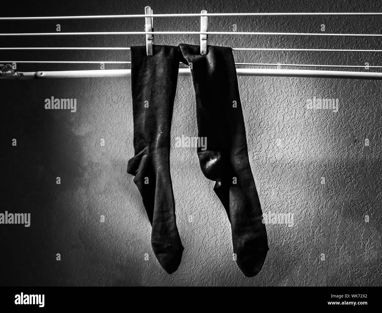 Socks Drying On Clothesline Against Wall Stock Photo - Alamy