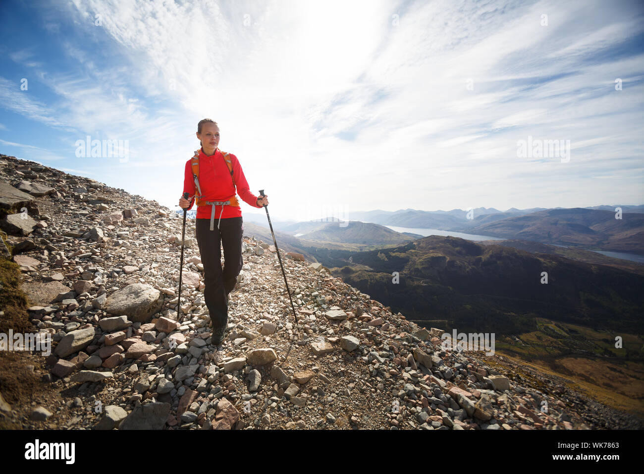Pretty, young female hiker going uphill Stock Photo - Alamy