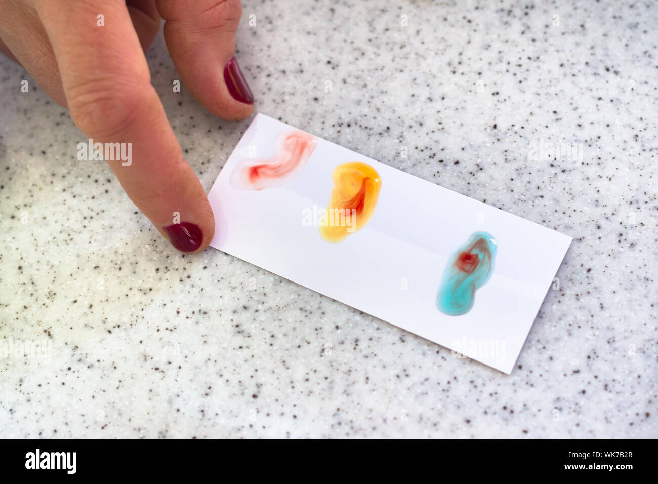 Medical doctor performing a quick blood group determination by using ...