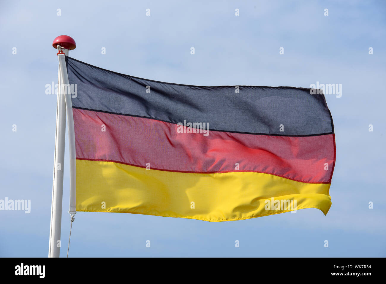 German flag waving on the wind against blue sky Stock Photo - Alamy