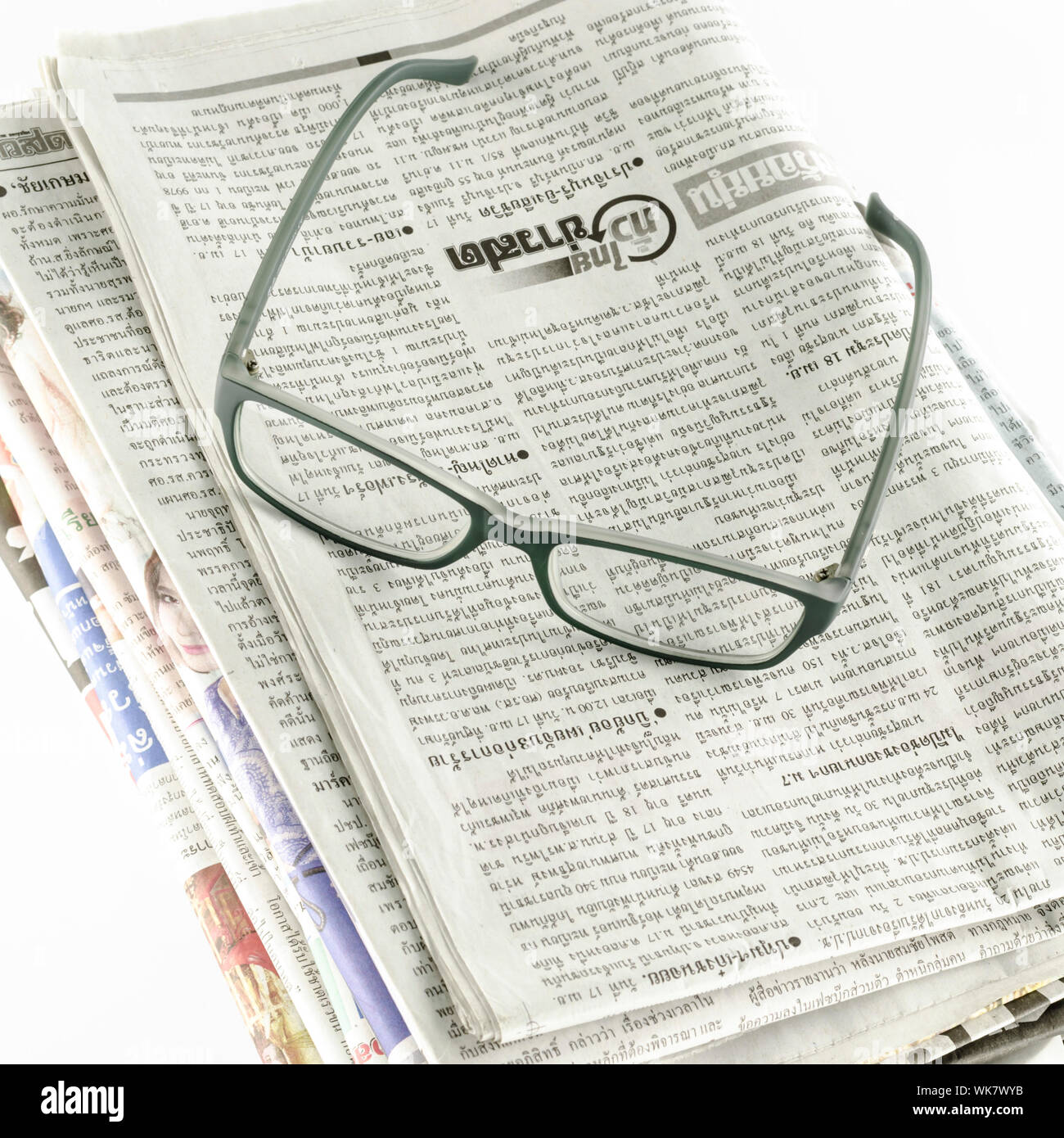 stack of newspaper with glasses on a white background Stock Photo - Alamy