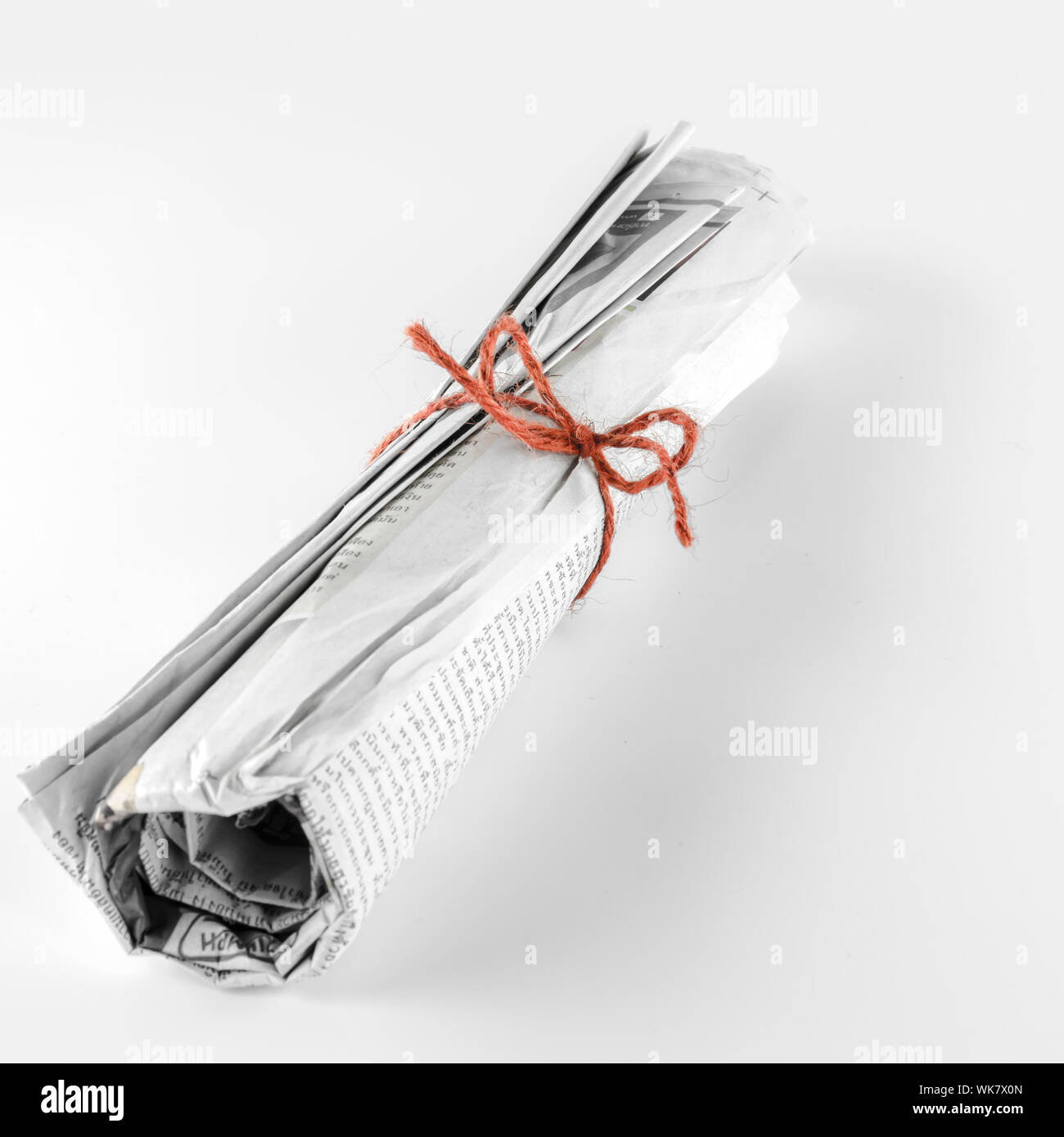 rolled up newspaper focus on red rope on a white background Stock Photo ...