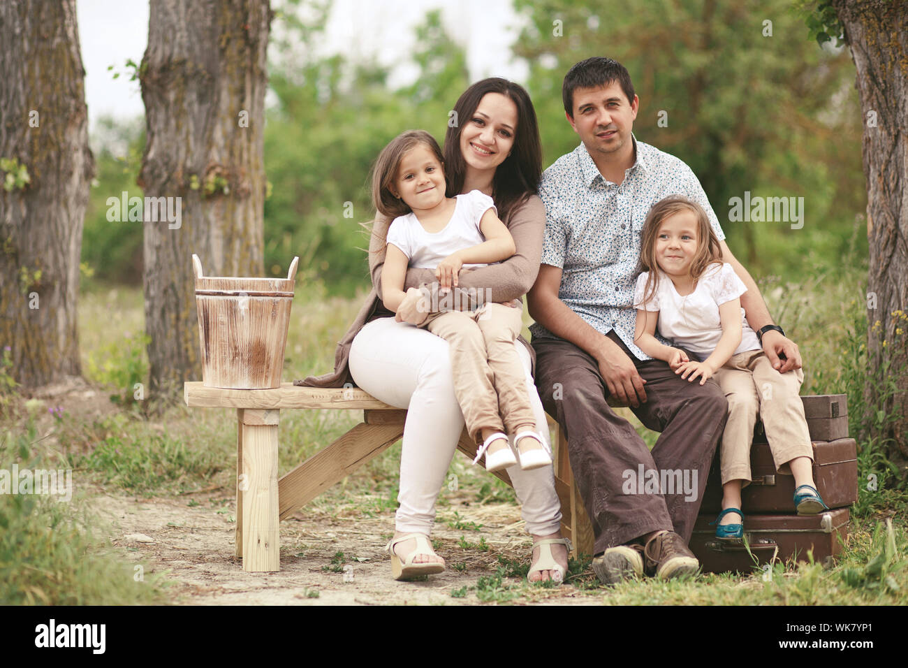 Family portrait outdoor on wooden bench in rustic style Stock Photo - Alamy