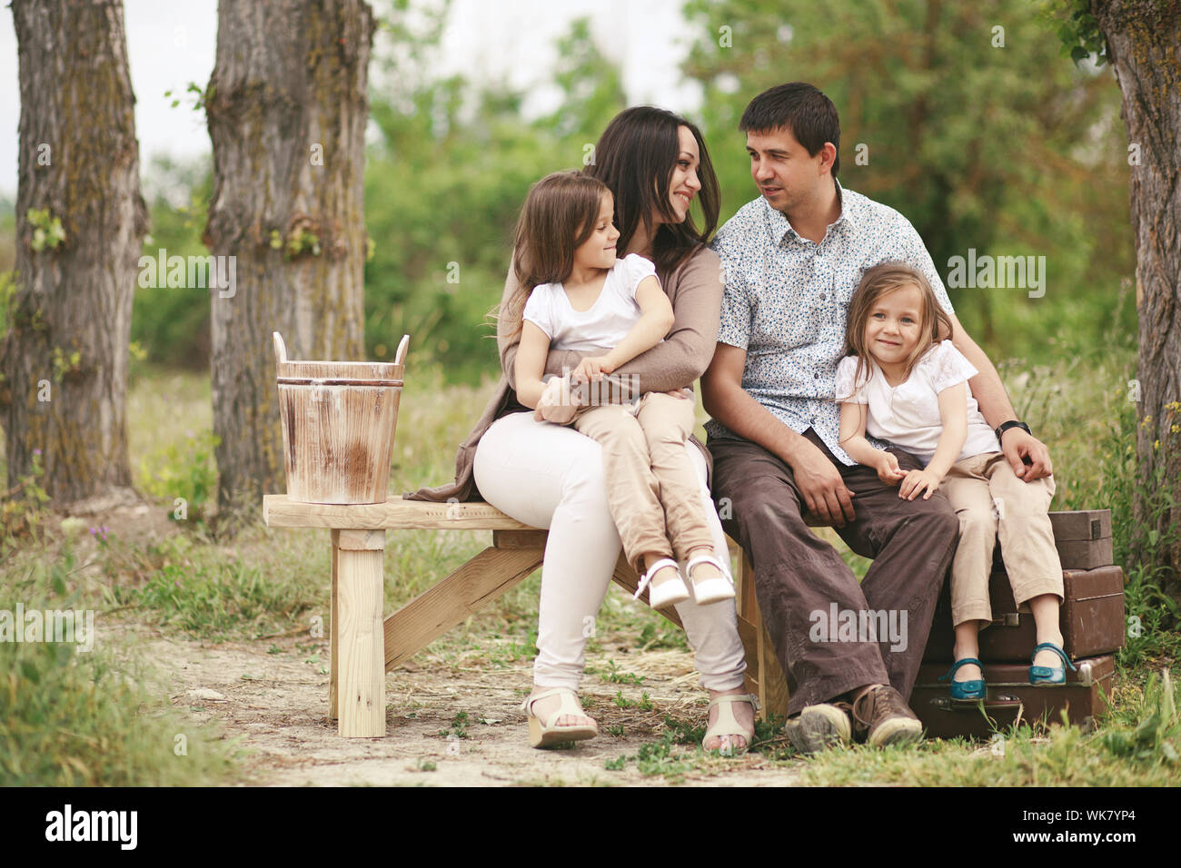 Family portrait outdoor on wooden bench in rustic style Stock Photo - Alamy