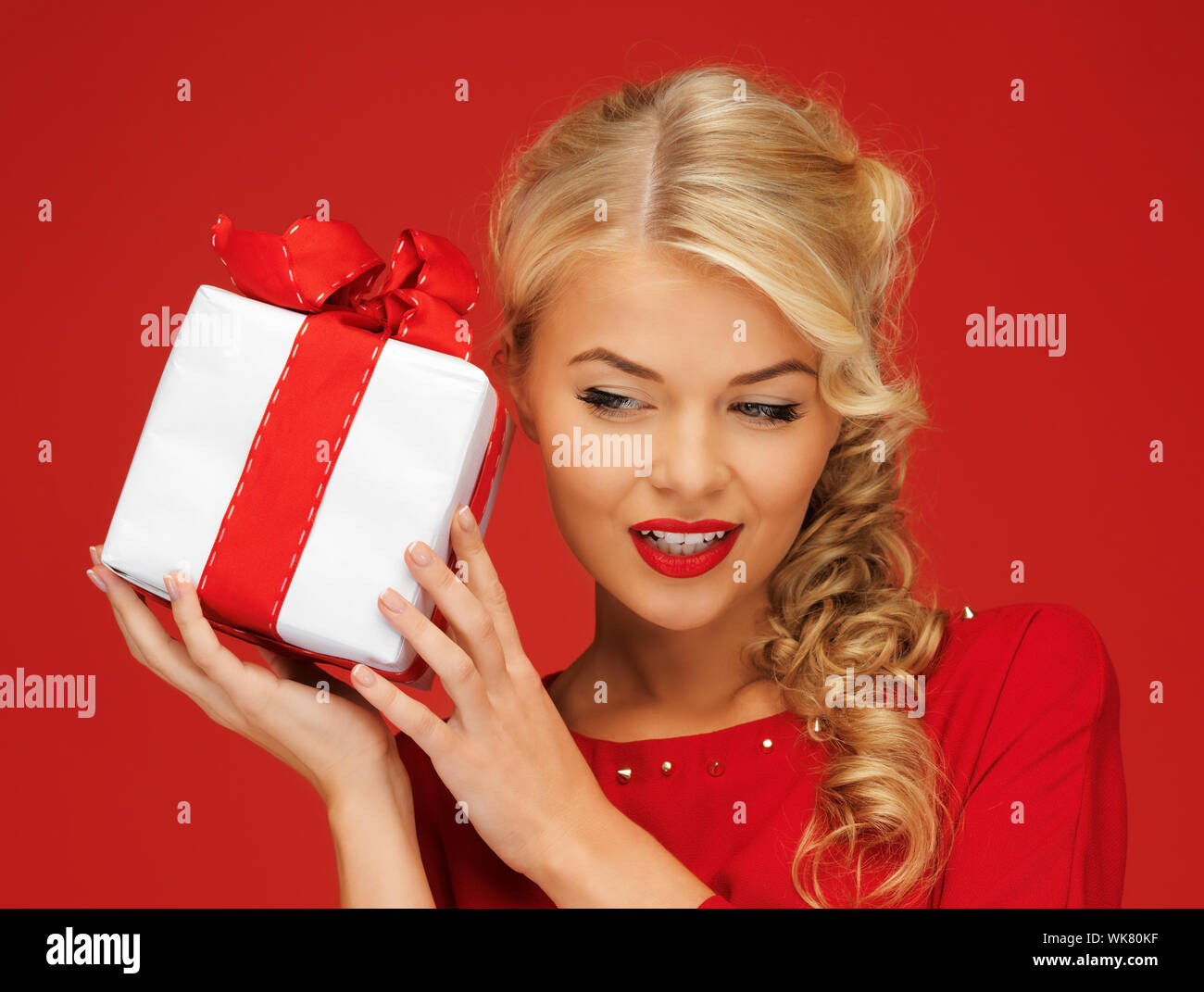 lovely woman in red dress with present Stock Photo - Alamy