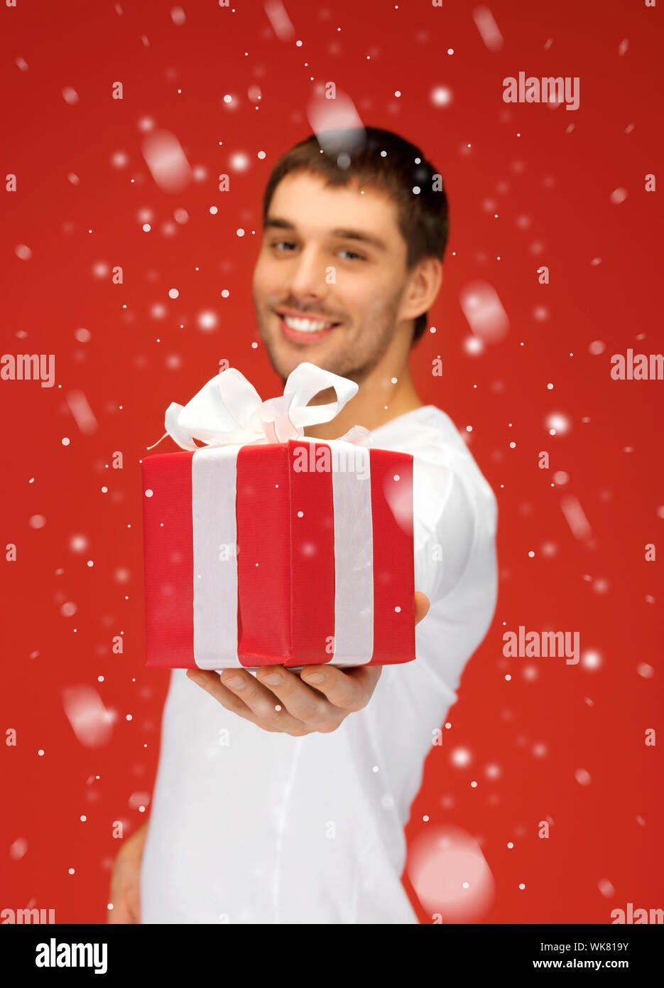bright picture of handsome man with a gift (focus on box Stock Photo ...