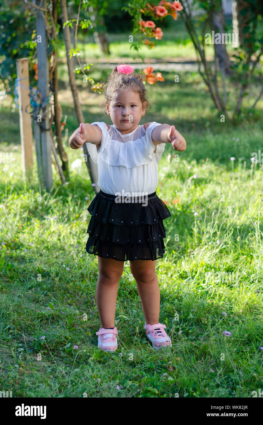 Cute caucasian kid standing in the garden success sign doing positive ...