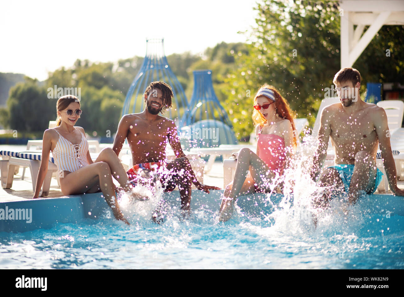 Couples splashing water in the pool while having rest together Stock ...