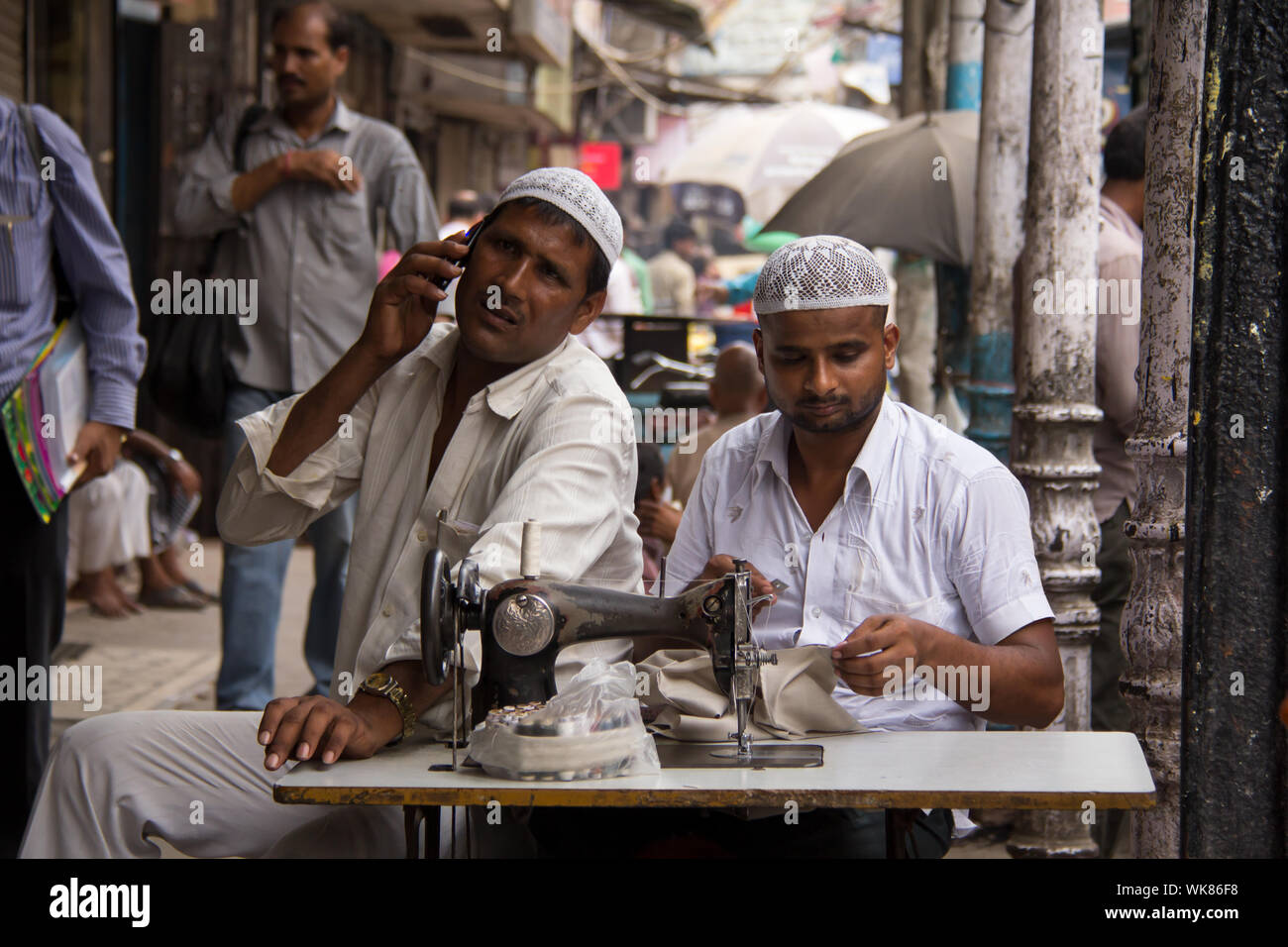 Tailor stitching cloth on a sewing machine in a street, New Delhi ...