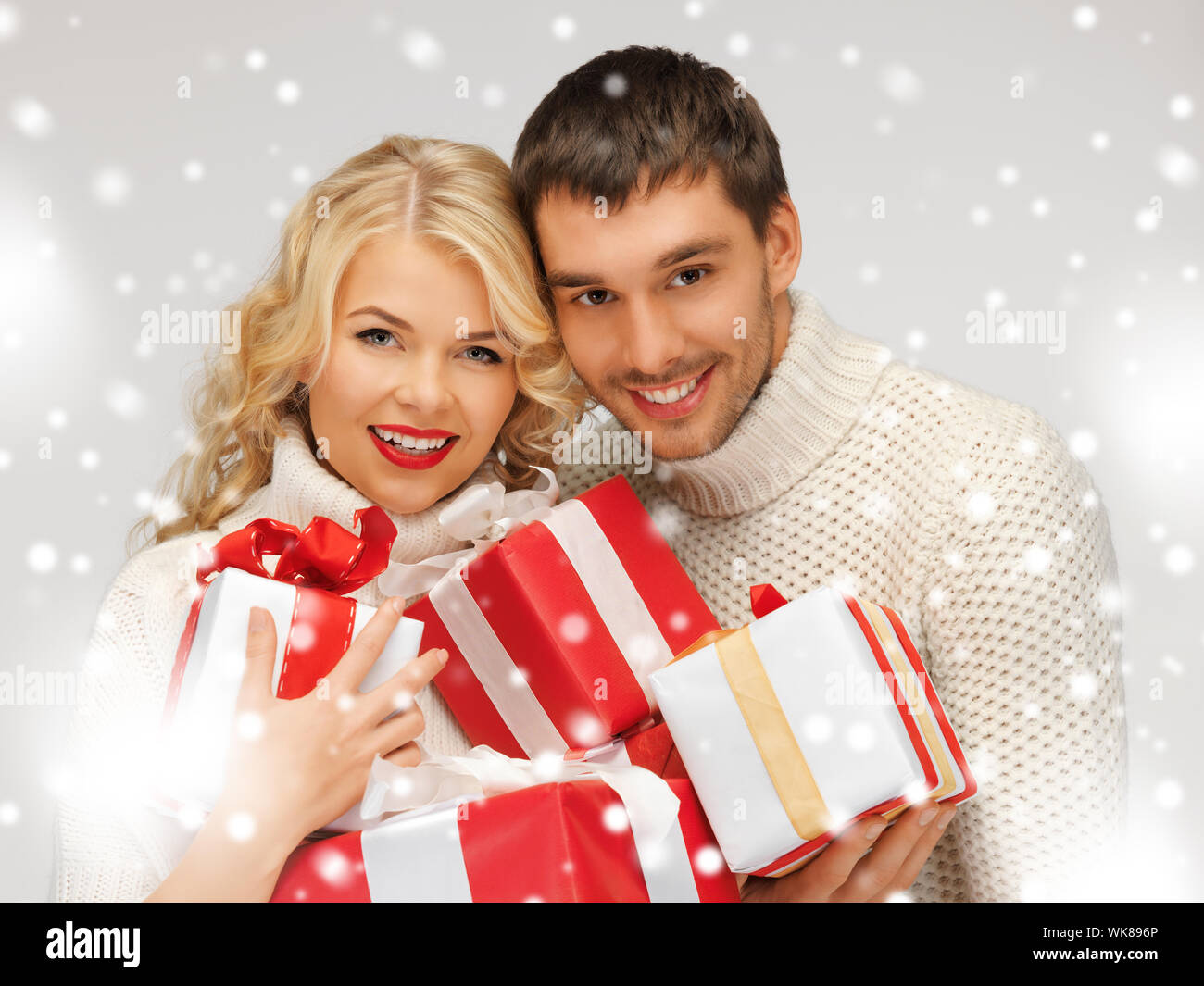 romantic couple in a sweaters with gift boxes Stock Photo - Alamy
