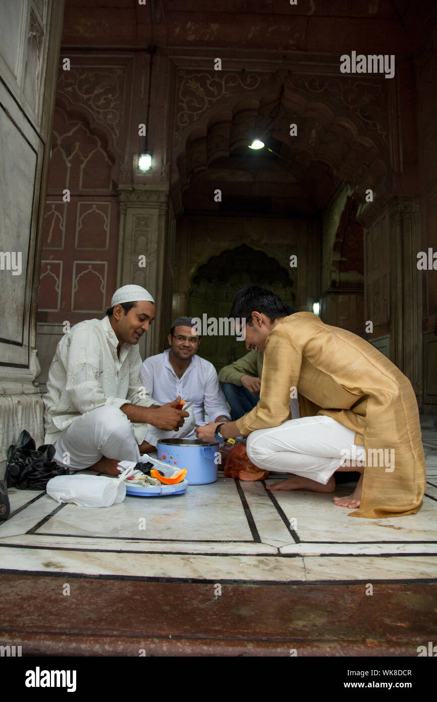 Group of people cutting papaya at a mosque, Jama Masjid, Old Delhi ...