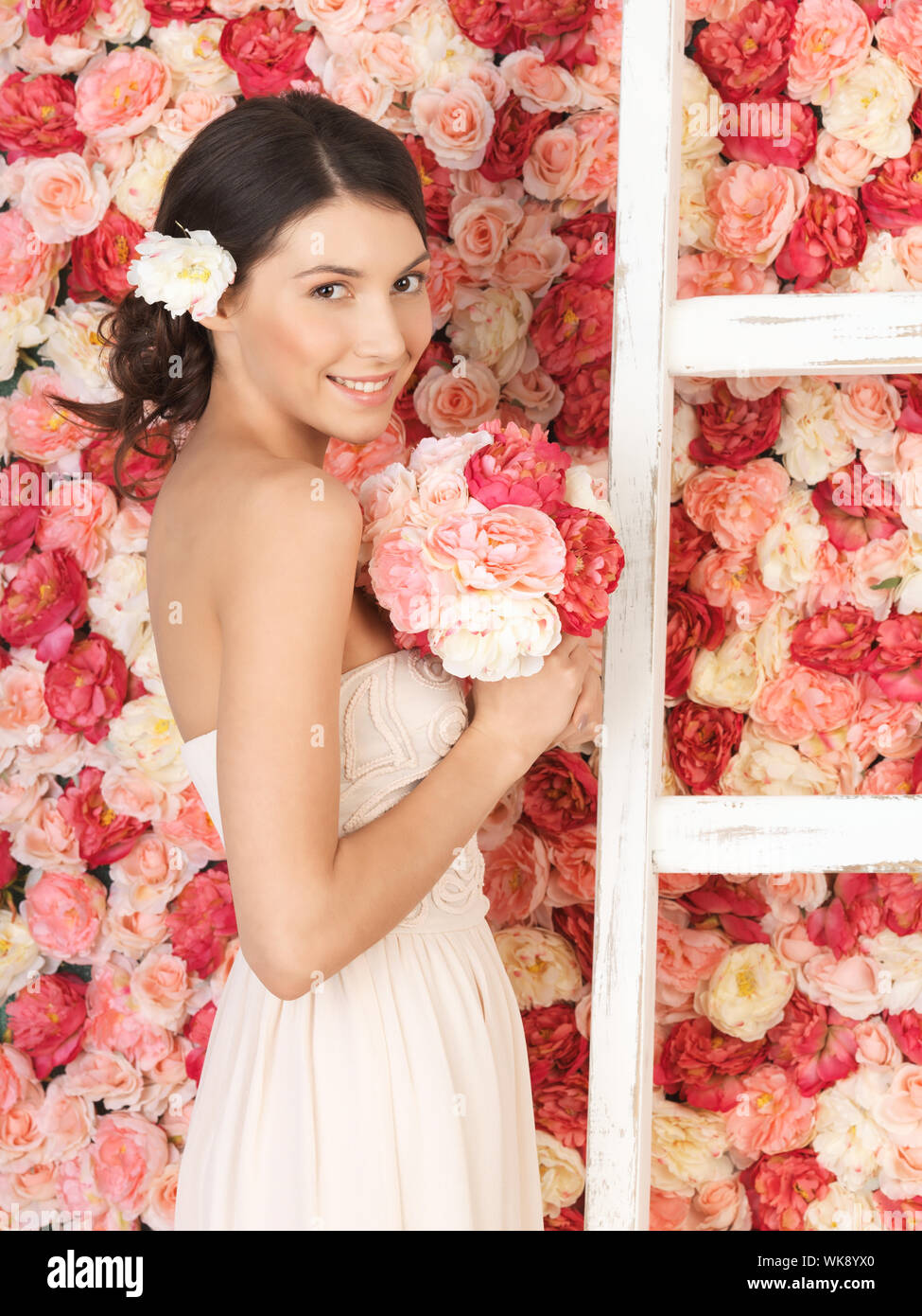 woman with bouquet of flowers and background full of roses Stock Photo ...