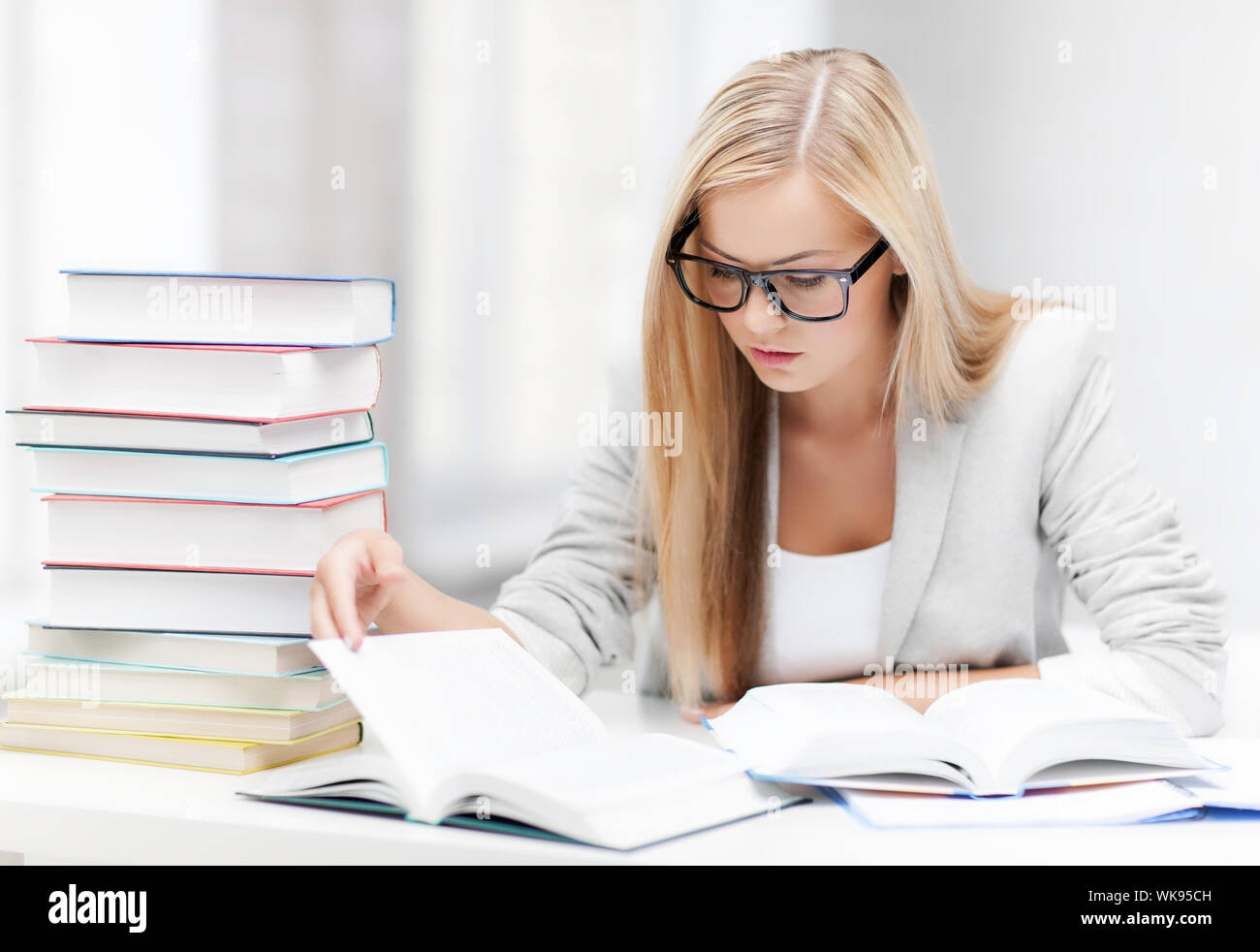 student with pile of books and notes studying indoors Stock Photo - Alamy