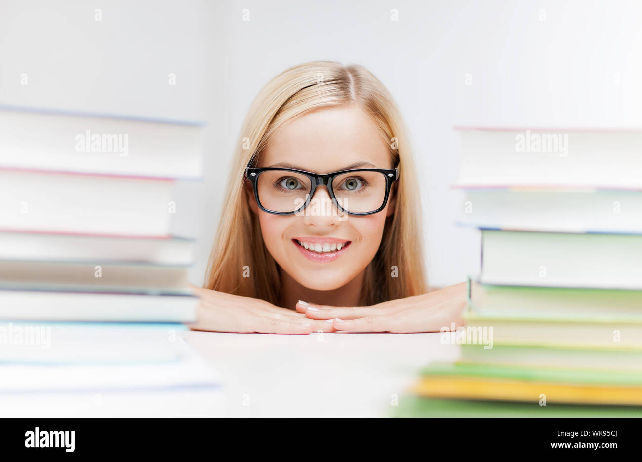 picture of smiling student with stack of books Stock Photo - Alamy