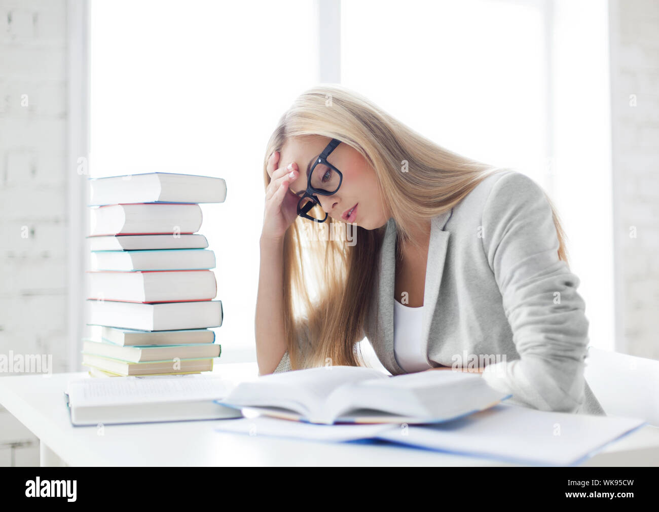 student with pile of books and notes studying indoors Stock Photo - Alamy