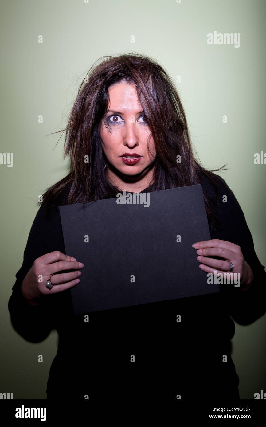 Deranged looking woman in mugshot with blank board Stock Photo - Alamy