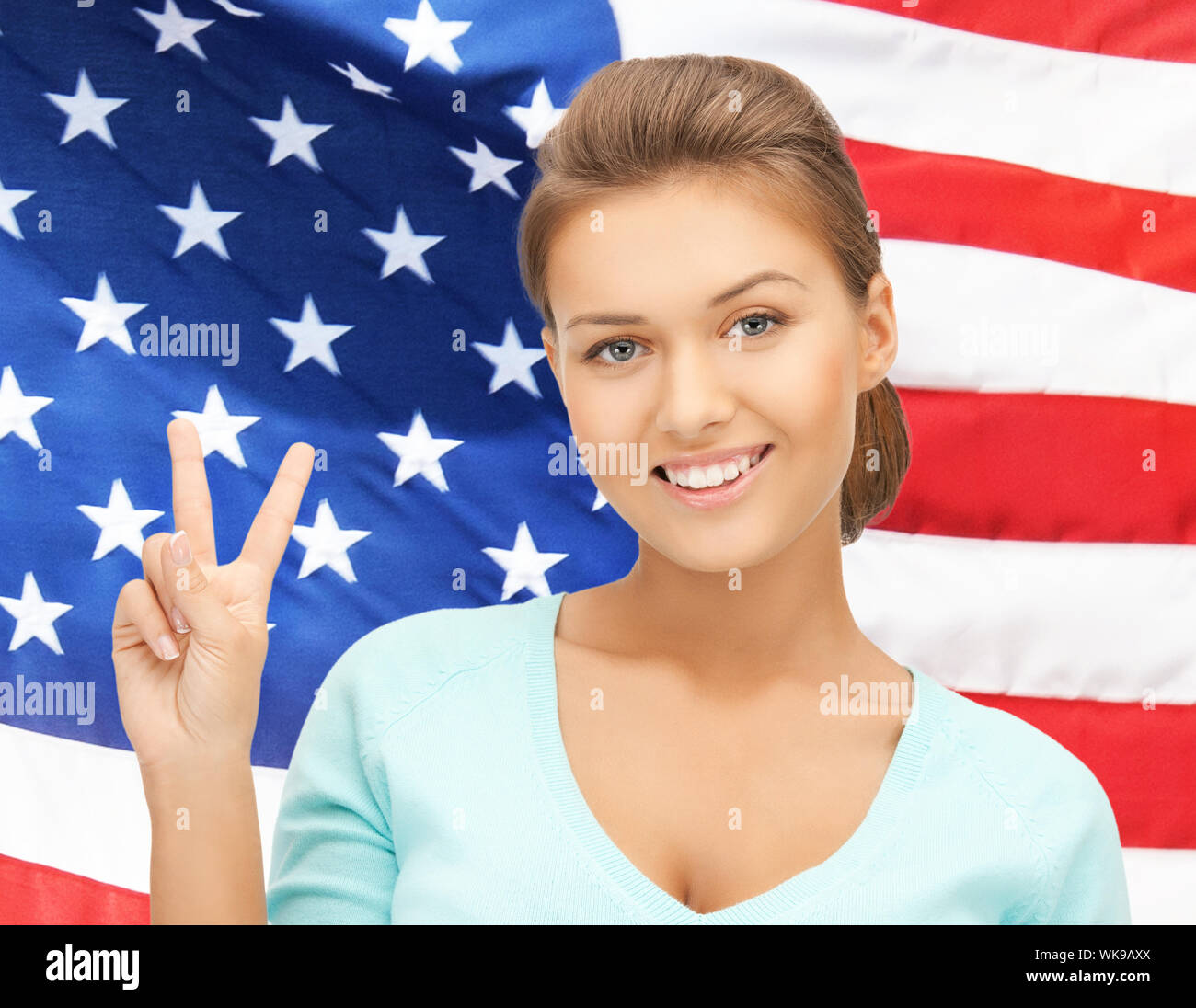 young woman showing victory or peace sign Stock Photo - Alamy
