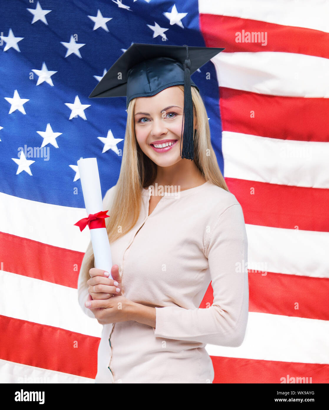 happy student in graduation cap with certificate over american flag ...