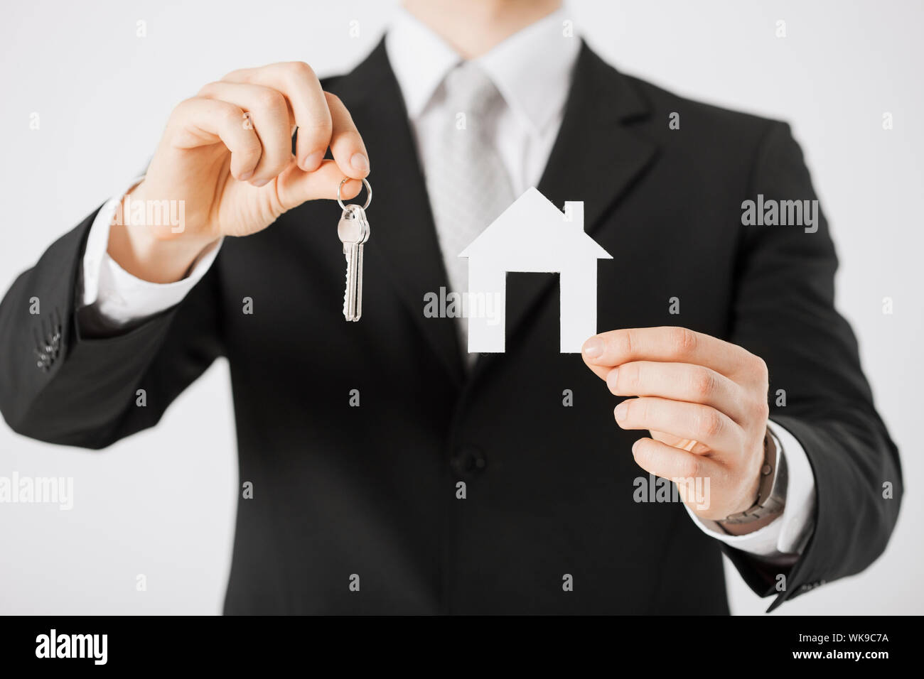 man hand holding house keys and paper house Stock Photo - Alamy