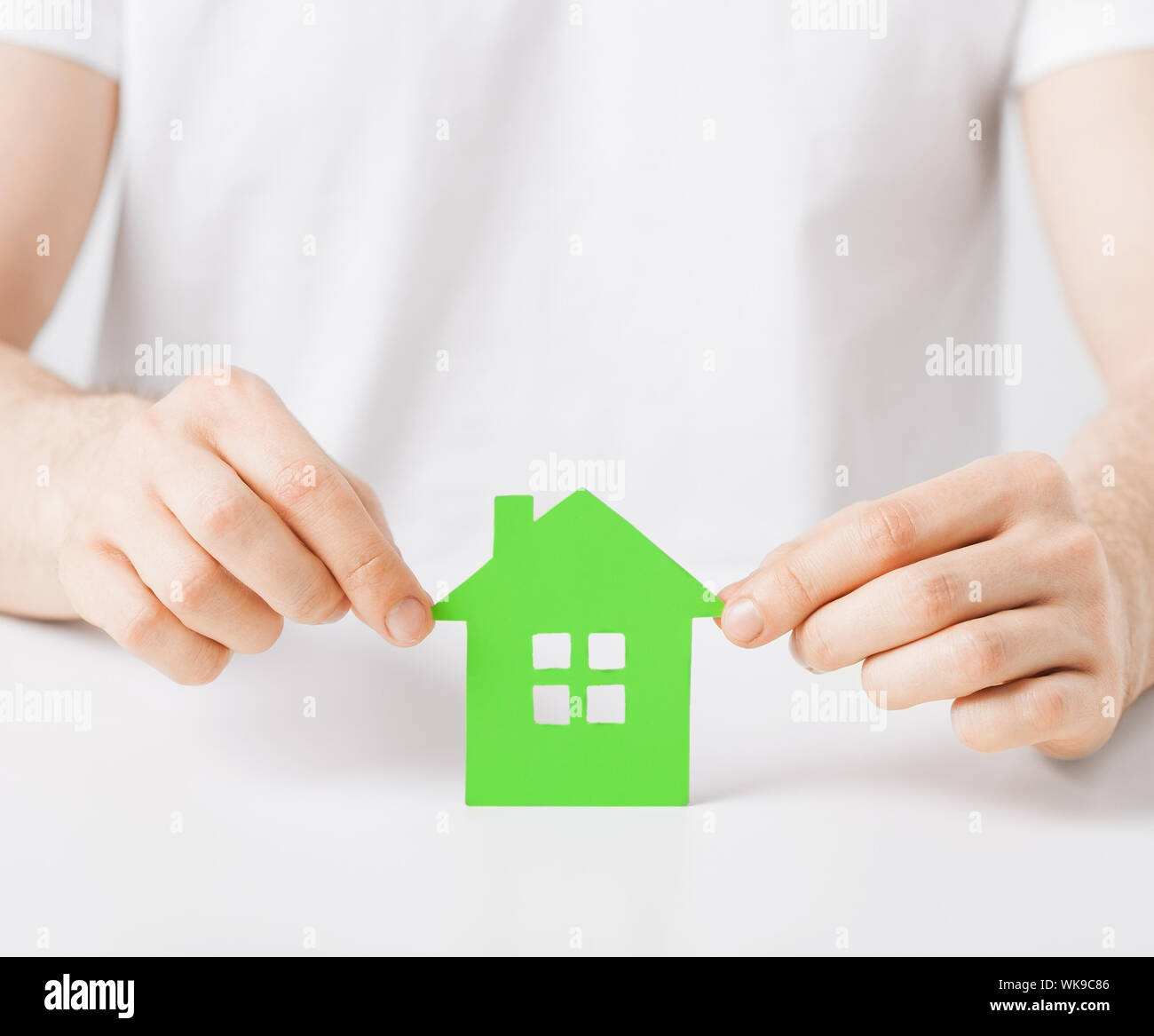 closeup picture of man hands holding green house Stock Photo - Alamy