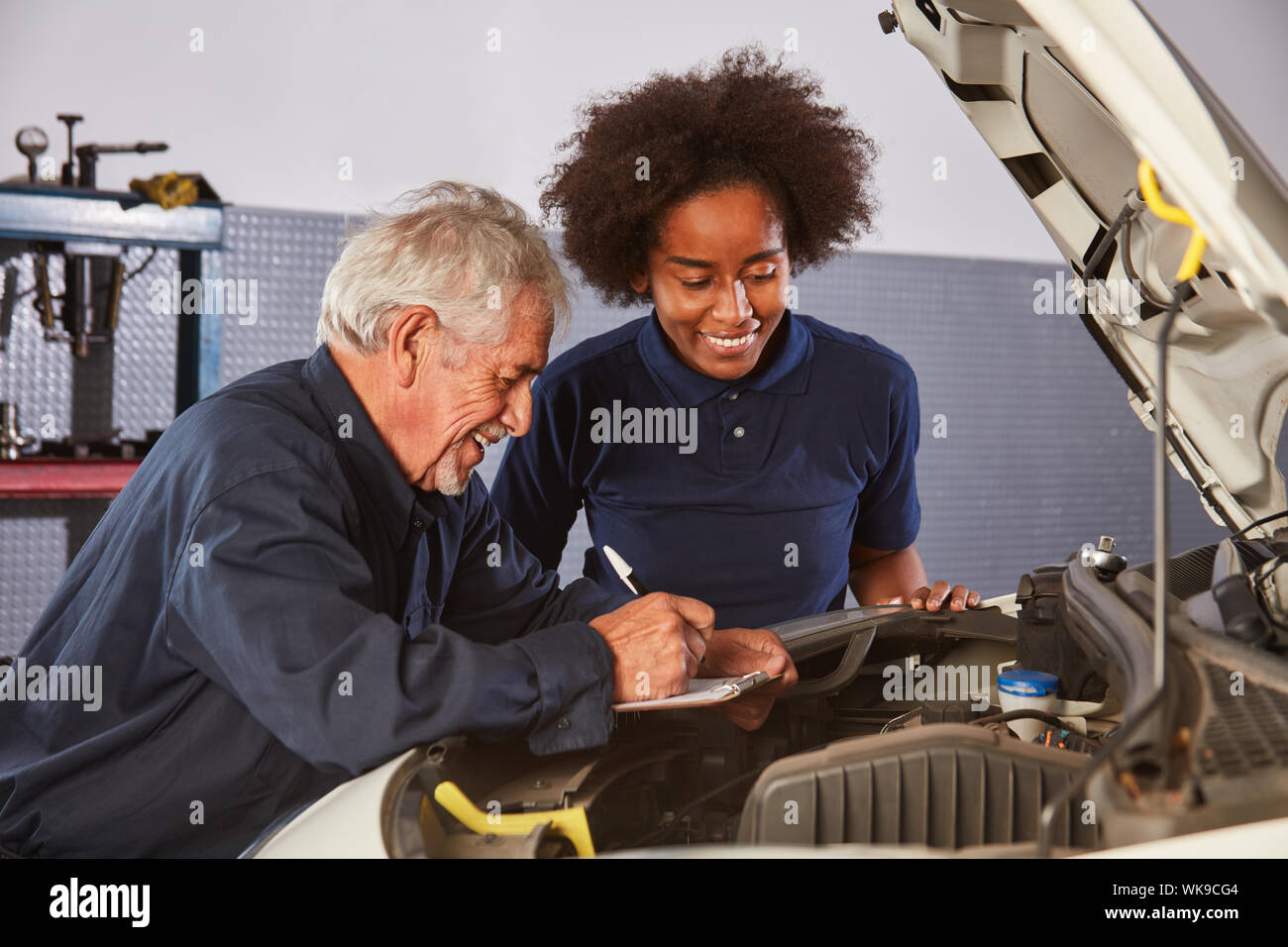 Car Master and African woman as a mechatronics apprentice at the auto ...