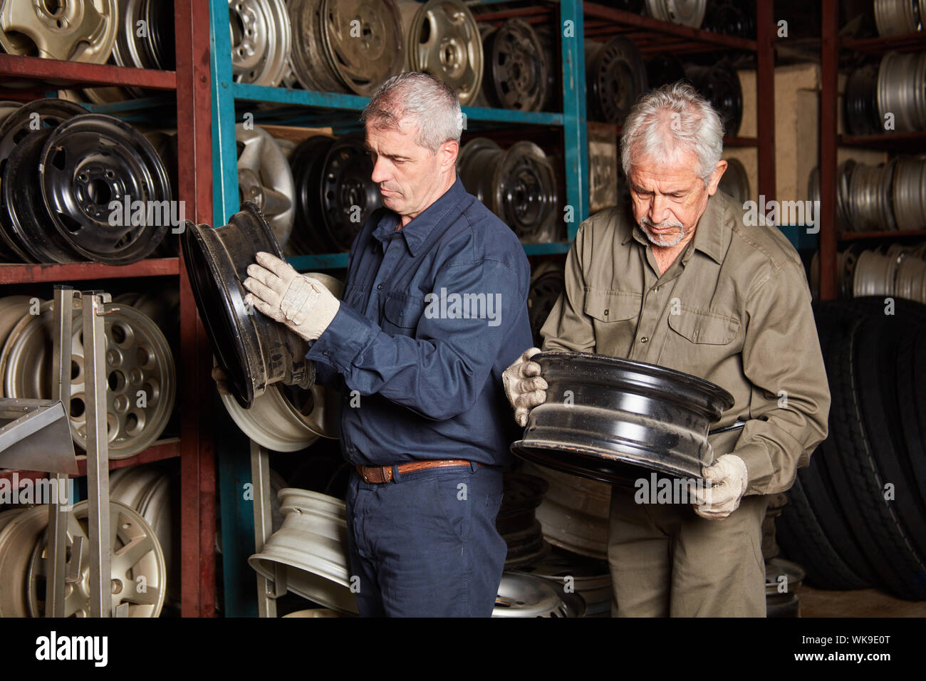 Car mechanic in the workshop Stock in the selection of new car wheels ...