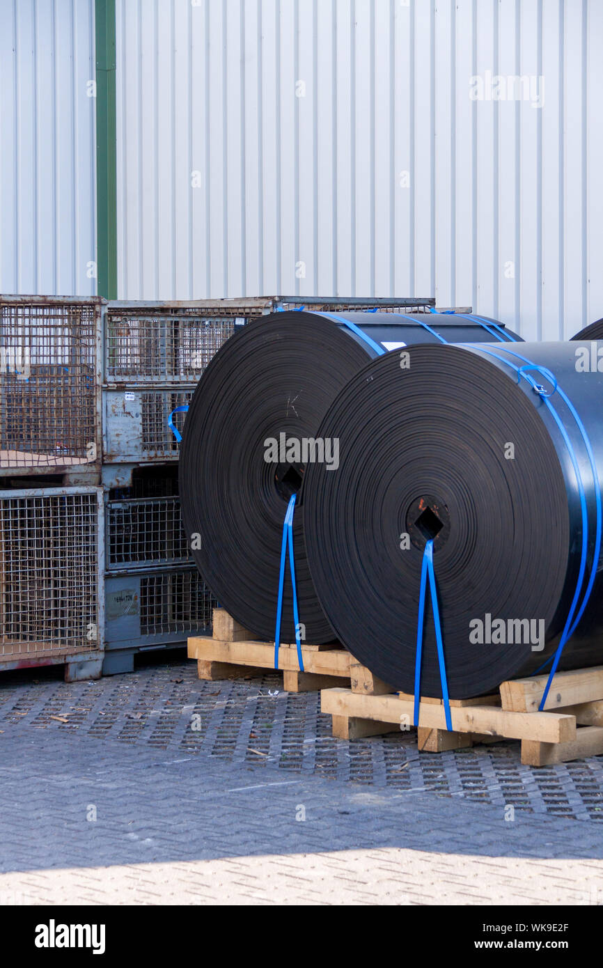 Rolls of black industrial plastic tied to wooden pallets outside a ...