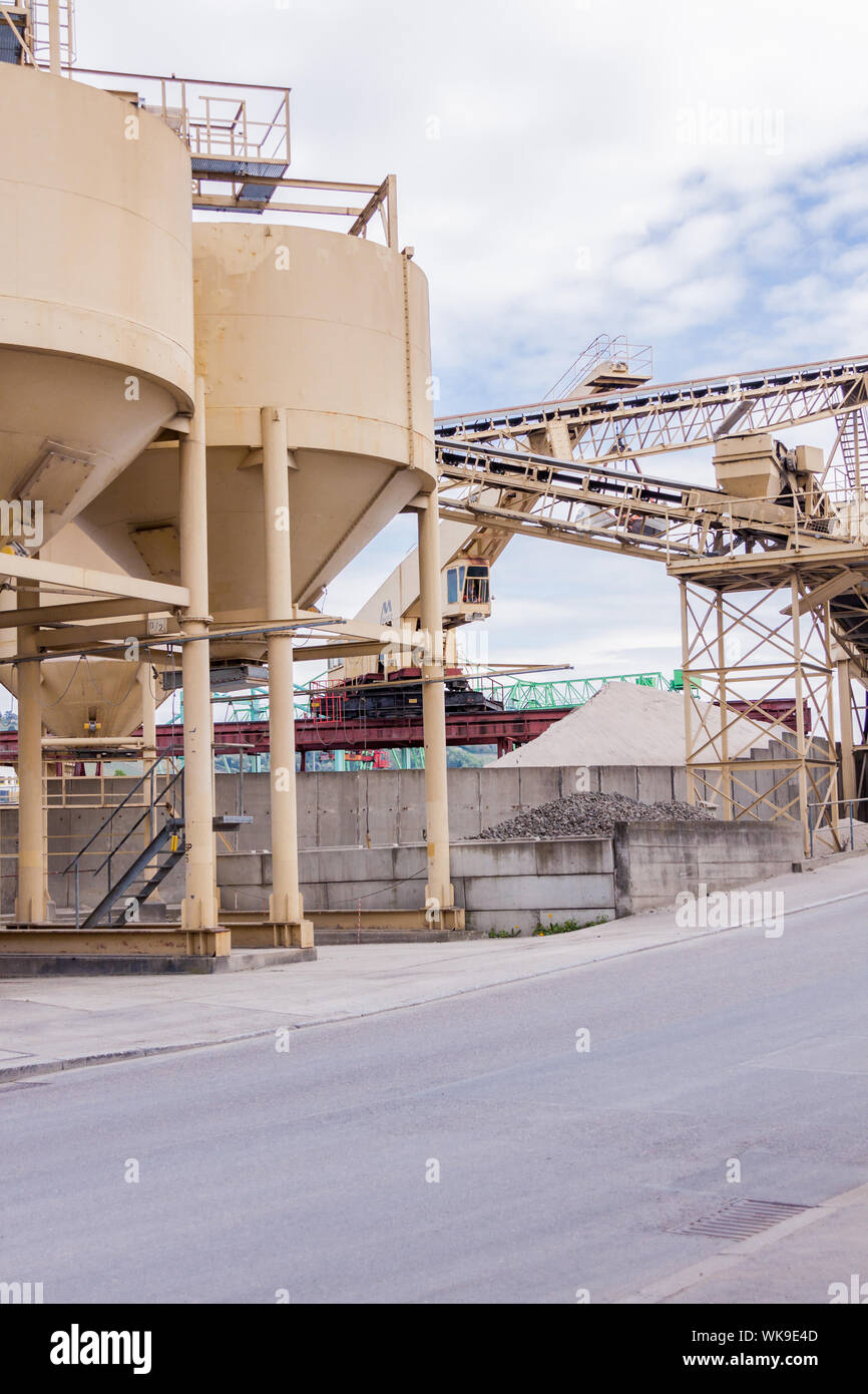 Row of large cylindrical metal tanks or silos at a refinery plant ...
