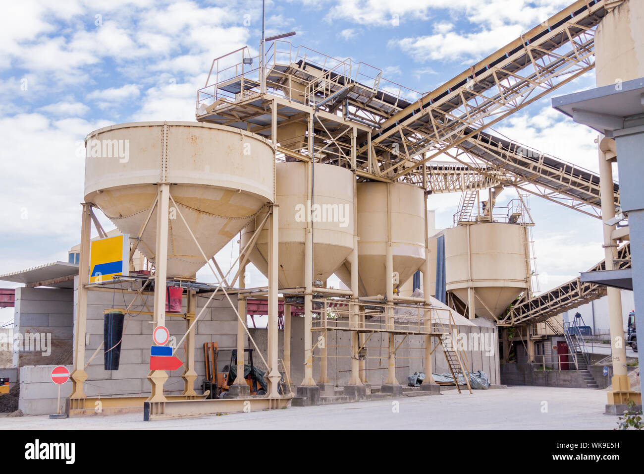 Row of large cylindrical metal tanks or silos at a refinery plant ...