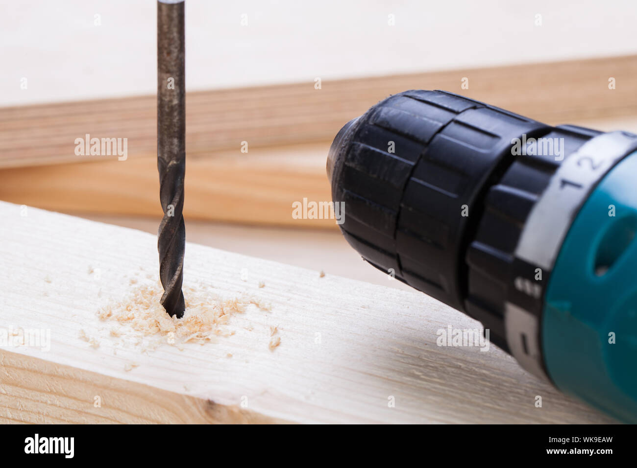 Battery operated hand drill standing amongst planks of new wood with a ...