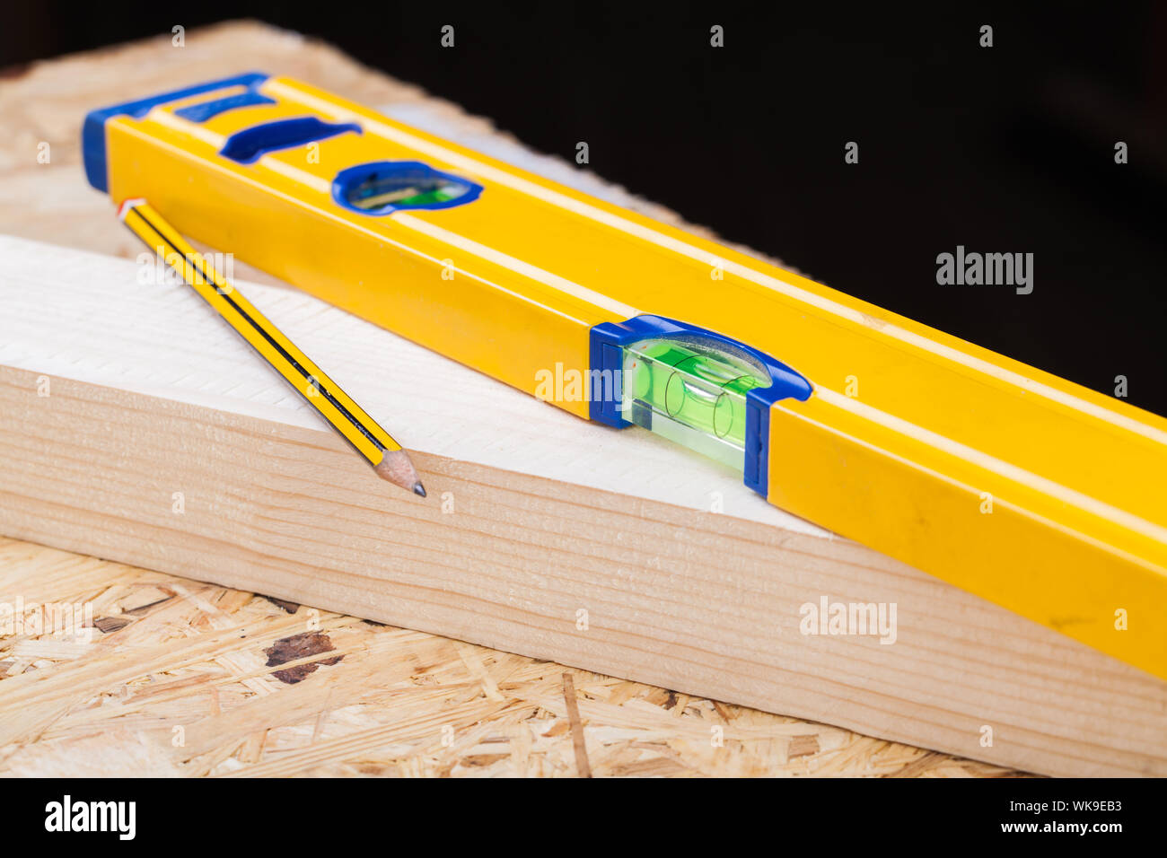 Close up view of a colorful yellow carpenters level, ruler and right ...