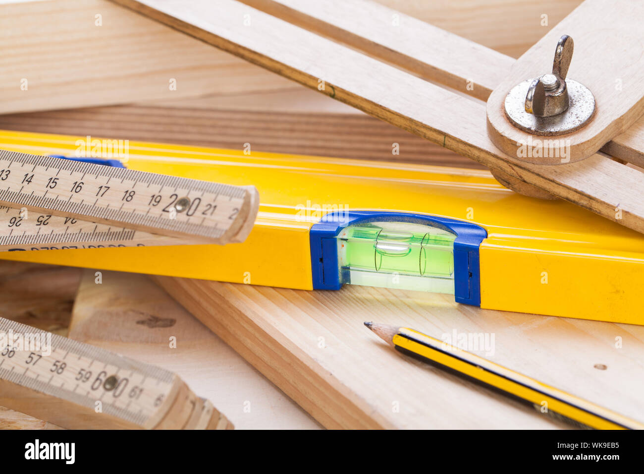 Close up view of a colorful yellow carpenters level, ruler and right ...