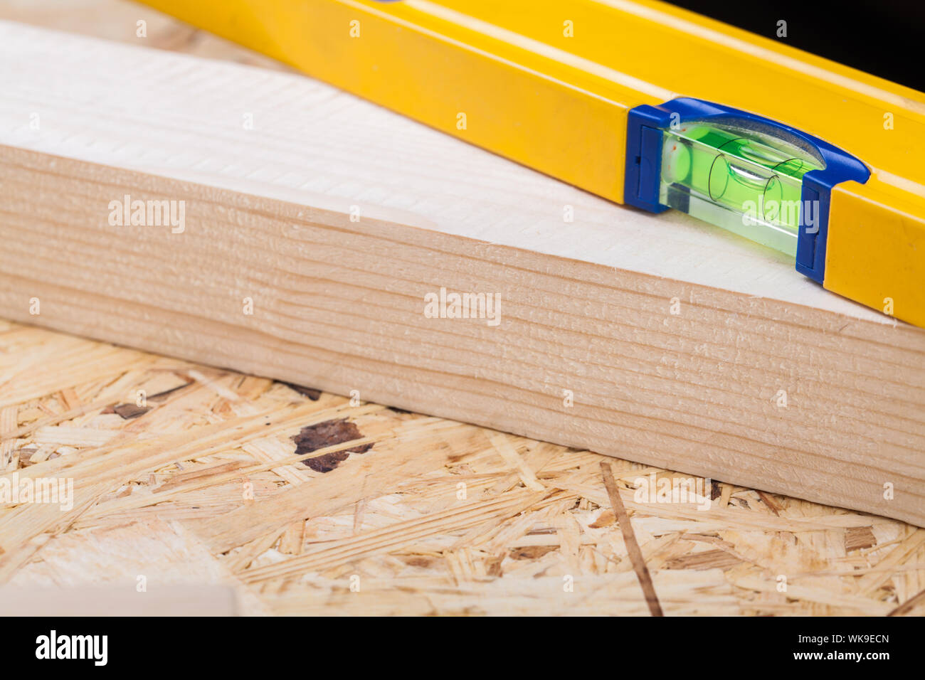 Close up view of a colorful yellow carpenters level, ruler and right ...