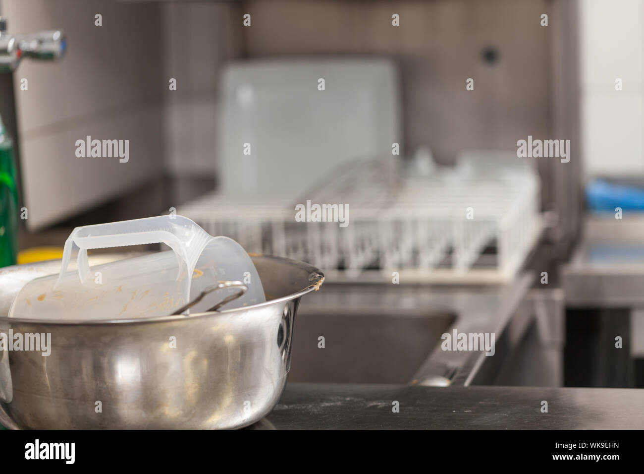 Neat interior of a commercial kitchen with wall mounted utensils and a ...