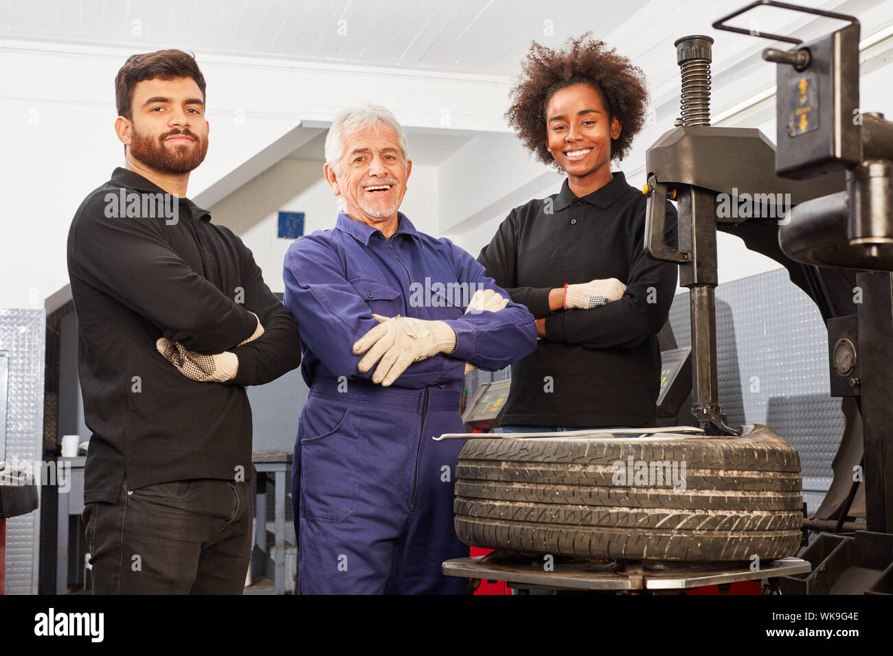 Proud mechanic and mechatronics team with crossed arms in the workshop ...